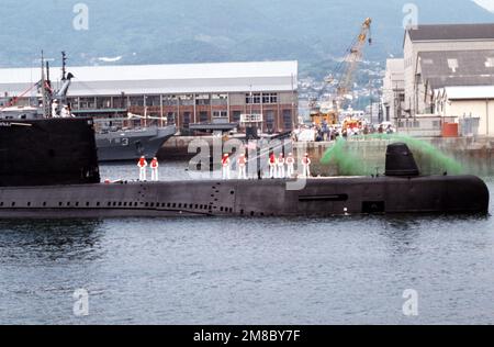 Crew members stand atop the attack submarine USS DARTER (SS 576) as the ...