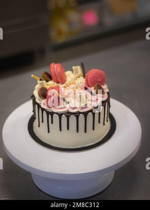 A vertical shot of a dripping chocolate cake with strawberries on a ...