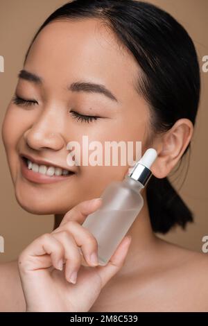 Face serum, eyes closed or model woman in studio on beige background ...