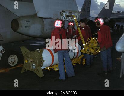 Ordnancemen use an HLU-196 bomb hoist to load a Mark 84 2,000-pound ...
