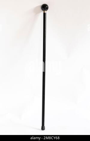 A vertical shot of a black walking cane isolated on white background ...