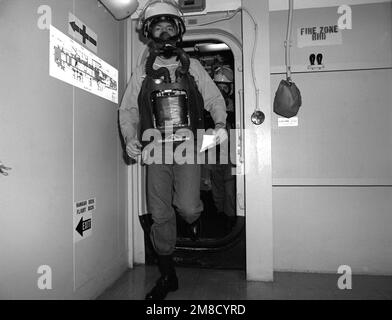 Crewmen, wearing oxygen breathing apparatus, prepare for a fire ...