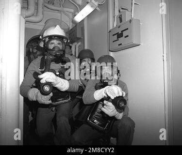 Crew members wearing oxygen breathing apparatus practice firefighting ...