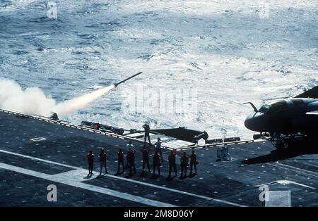 Crew members watch as a trainer missile is launched from a Mark 29 NATO ...