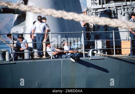 Sailors aboard the destroyer USS HEWITT (DD 966) haul in on a line as ...
