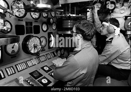 Sailors monitor the gauges on a control panel in the engine room aboard the Canadian frigate ...