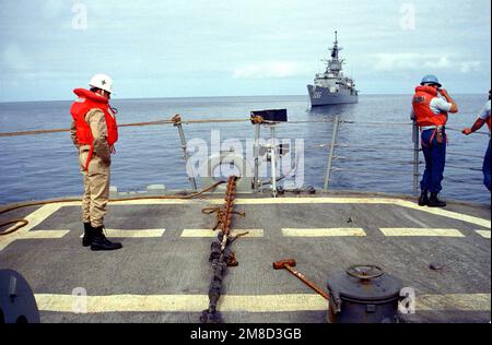 Crew members stand by on the stern of the guided missile destroyer USS ...