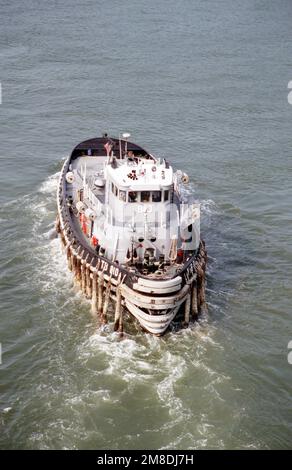The large harbor tug Anoka (YTB-810) assist the guided missile cruiser ...