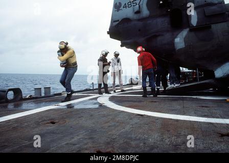 A crewman aboard the tank landing ship USS SUMTER (LST 1181) uses ...