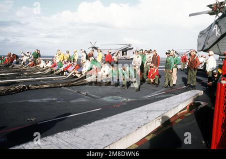 Flight deck crew members spread out the crash barricade during a drill ...