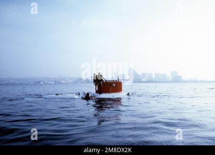 Crew members stand on the hull of the U.S. Navy deep submergence ...