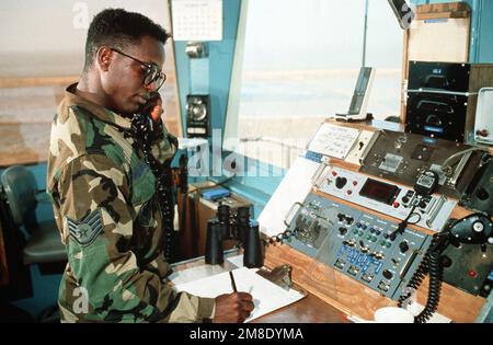 An Air Force staff sergeant communicates with the pilot of an incoming ...
