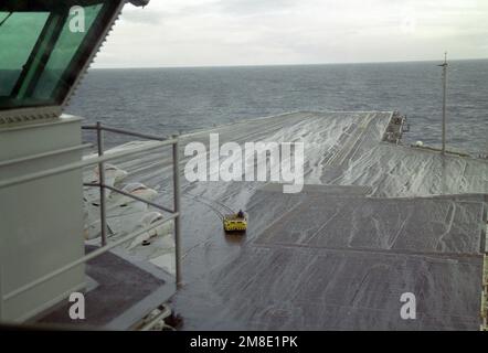 An MD-3A tow tractor leaves tracks as rain and wind produce an icy ...
