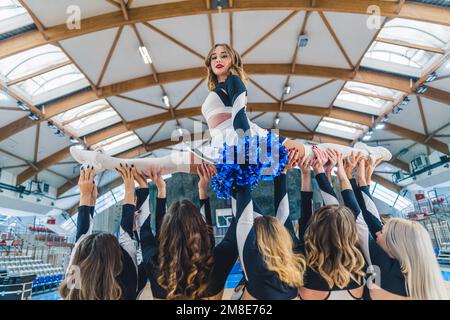 A group of cheerleaders are captured in a dynamic and athletic moment ...