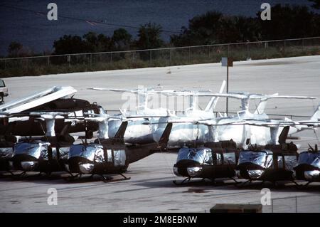 A line of UH-1H Iroquois helicopters carry personnel into the field for ...