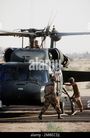 A soldier refuels a UH-60 Black Hawk (Blackhawk) helicopter during ...