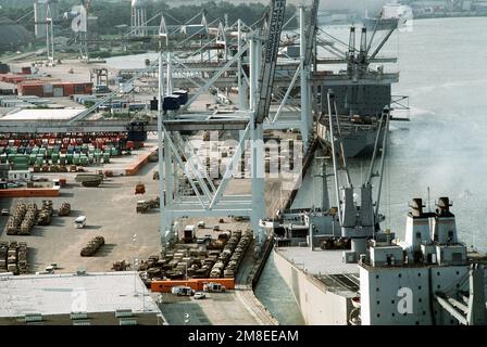 Cranes aboard the vehicle cargo ship USNS ALTAIR (T-AKR 291) lower ...