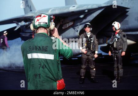 A squadron member photographs the pilot and radar intercept officer of a Fighter Squadron 74 (VF ...