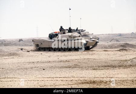 Two Marine Corps M-1A1 Abrams main battle tanks move across the desert ...