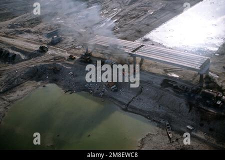 Demolished Iraqi vehicles line a roadway in the Euphrates River Valley ...
