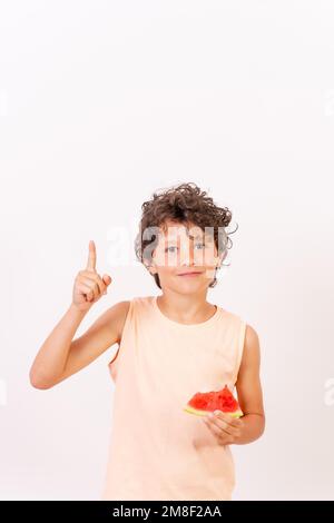 Boy eating a watermelon and pointing up, summer vacation. White ...