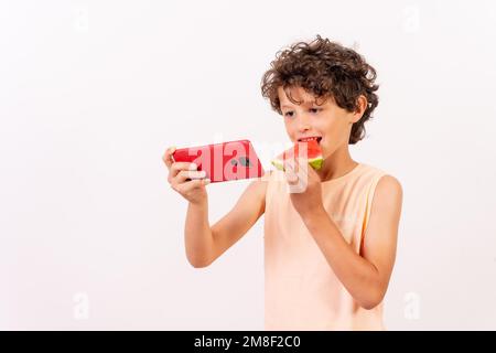 Boy eating a watermelon and taking a selfie, summer vacation. White ...
