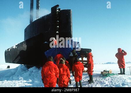 Crew members gather near the sail aboard the nuclear-powered attack ...