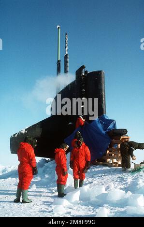 Crew members gather near the sail aboard the nuclear-powered attack ...