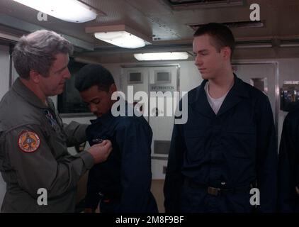 Undersecretary of the Navy Daniel Howard pins a submarine insignia to ...