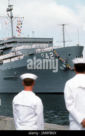 Line handlers stand by on the pier as the tank landing ship USS ...