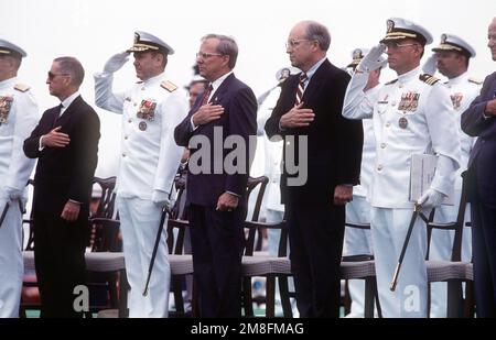 Officers and distinguished guests stand during the National Anthem at ...