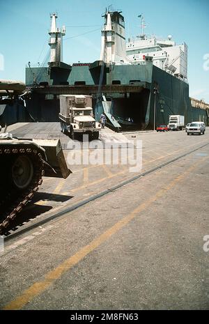 A 5-ton cargo truck carrying a shelter is driven onto the stern ramp of ...