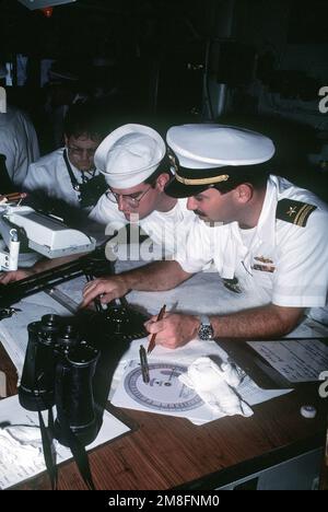 Crew members plot the course of the destroyer USS O'BANNON (DD 987) as ...