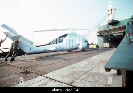 Soldiers of the 1181st Transportation Terminal Unit help push a UH-1H ...