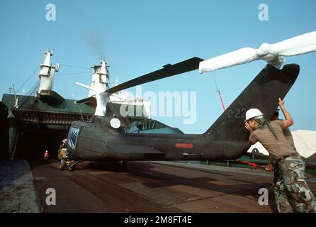 Soldiers of the 1181st Transportation Terminal Unit help push a UH-1H ...