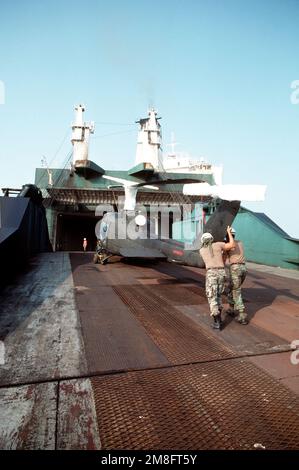 Soldiers of the 1181st Transportation Terminal Unit help push a UH-1H ...
