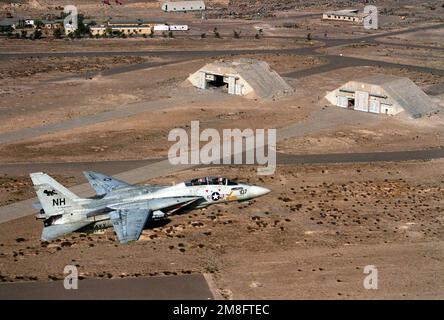 A Fighter Squadron 114 (VF-114) F-14A Tomcat aircraft flies over part ...
