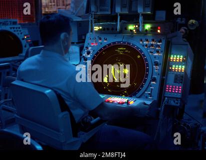 A crewman mans an air operations radar console in the combat direction ...