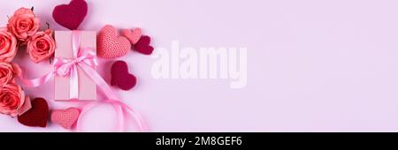 Pink roses, knitted pink hearts, gift box with a satin ribbon bow on a ...