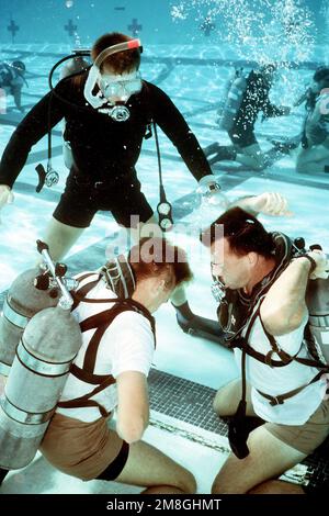 An instructor watches as students in a second class diver course rinse ...