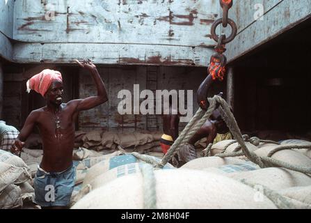Somali stevedores unload bags of grain from the merchant ship Erotas ...
