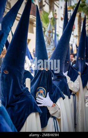 People in traditional dress weraing a capriote, or pointed hat in an ...