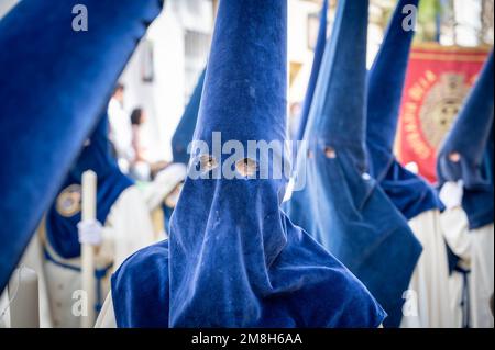 People in traditional dress weraing a capriote, or pointed hat in an ...