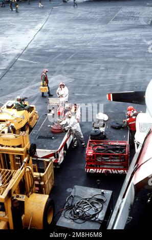 Members of the crash, rescue and salvage team stand by as flight deck ...