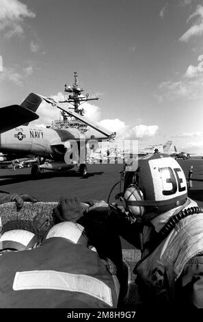 Members of the catapult crew take cover as a Fighter Squadron 14 (VF-14 ...