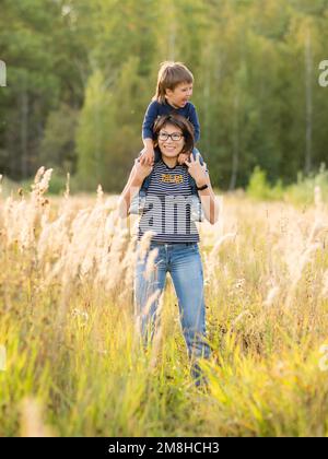 Happy parent and kid holding autumn yellow leaves outdoor Stock Photo ...
