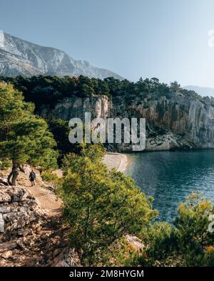 A high-angle of Nugal beach view on a sunny day, rocky cliffs and clear ...