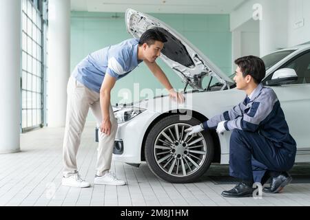 Repair shop mechanics of personnel with the customer Stock Photo - Alamy