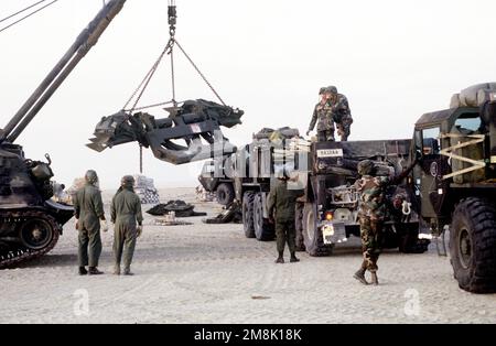 US soldiers load a mine plow for the M1A1 Abrams tank onto a cargo ...