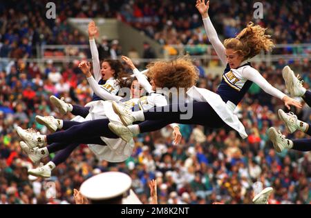 U.S. Naval Academy cheerleaders are tossed high in the air during the ...